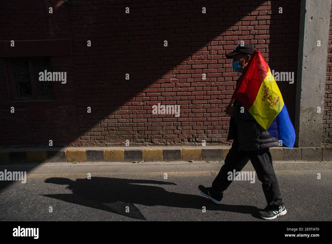 Kathmandu, Nepal. 1st Jan, 2021. A protester wearing a face mask holds ...