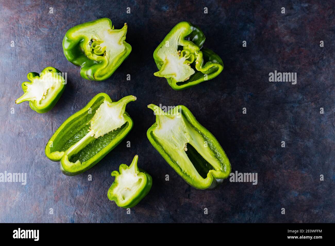 Ugly bell pepper on dark background. Sliced bell pepper halves on the ...