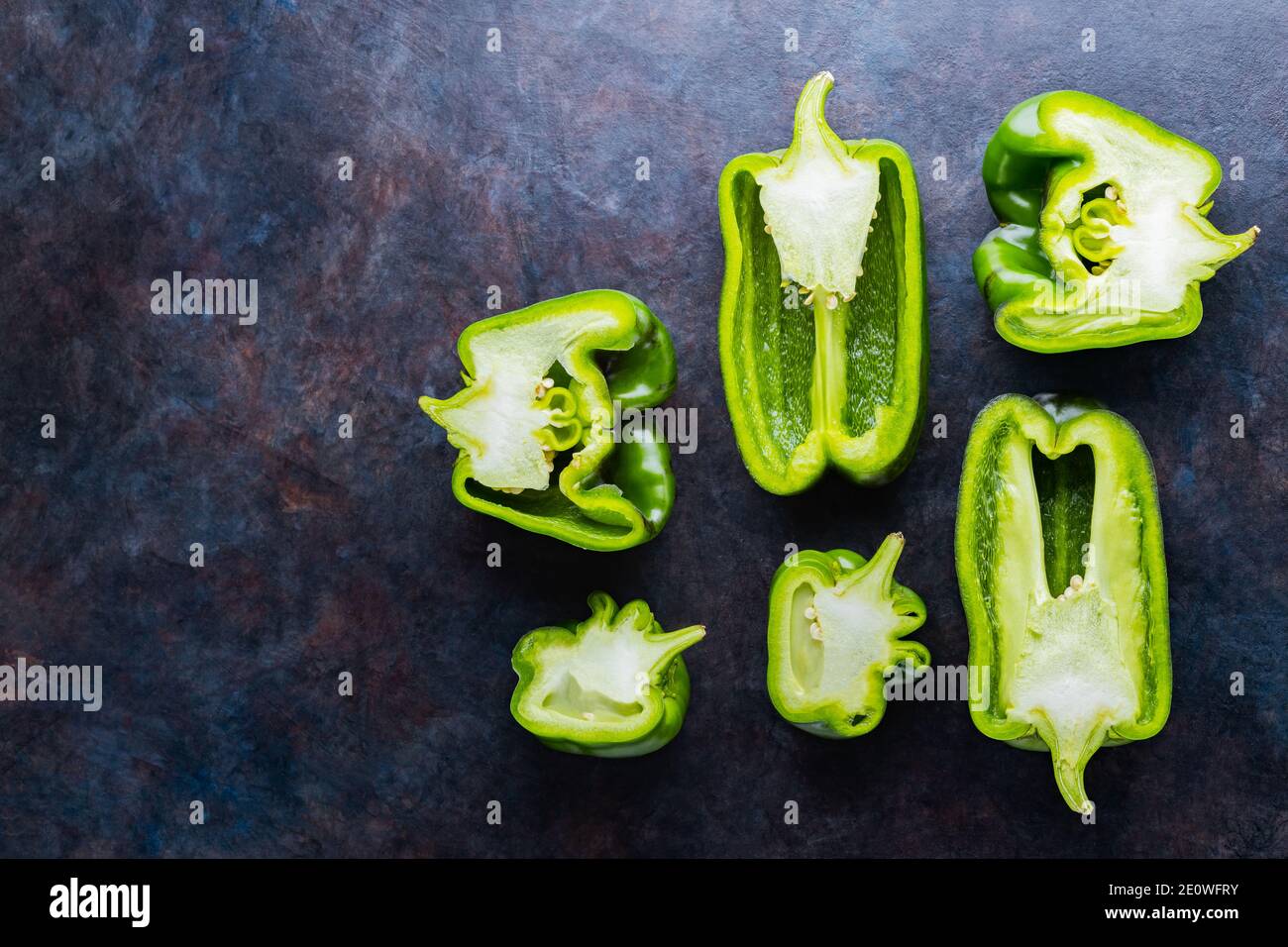 Ugly bell pepper on dark background. Sliced bell pepper halves on the ...
