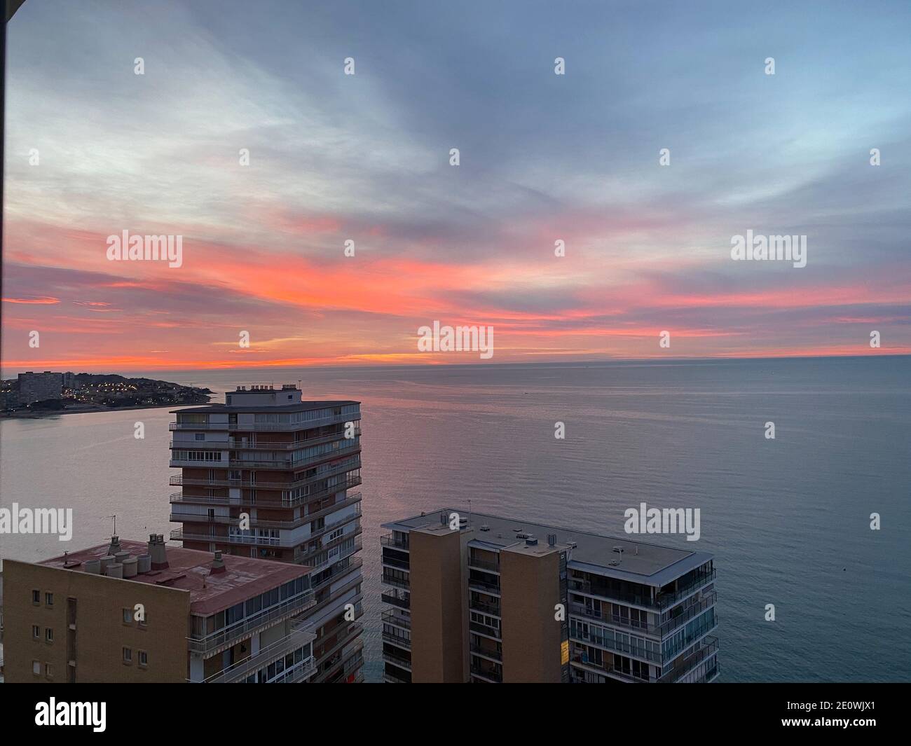 beautiful and colorful sunrise in the beach with some clouds in spain ...