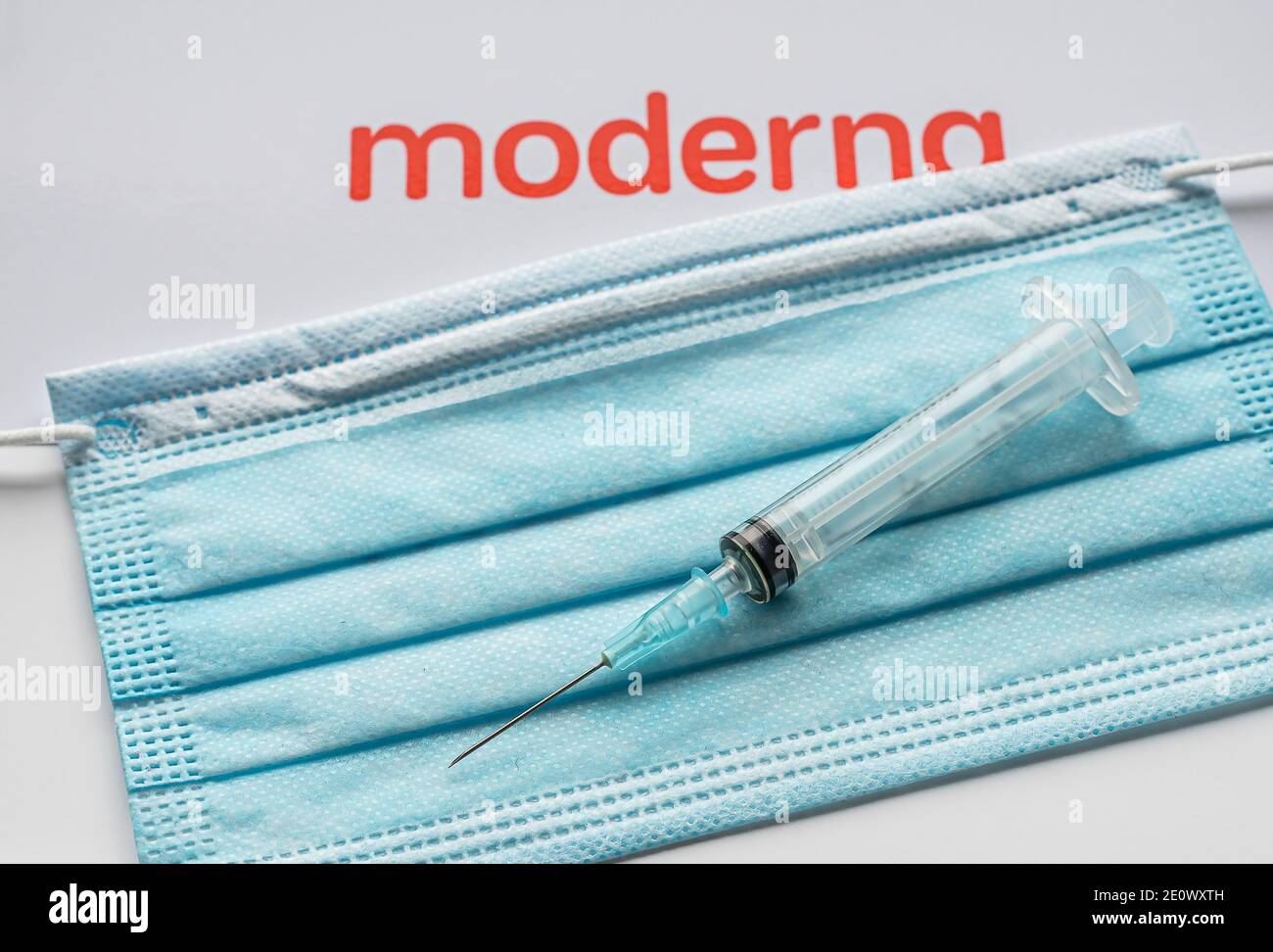 Moderna logo with a syringe and a face mask and the text merry ...