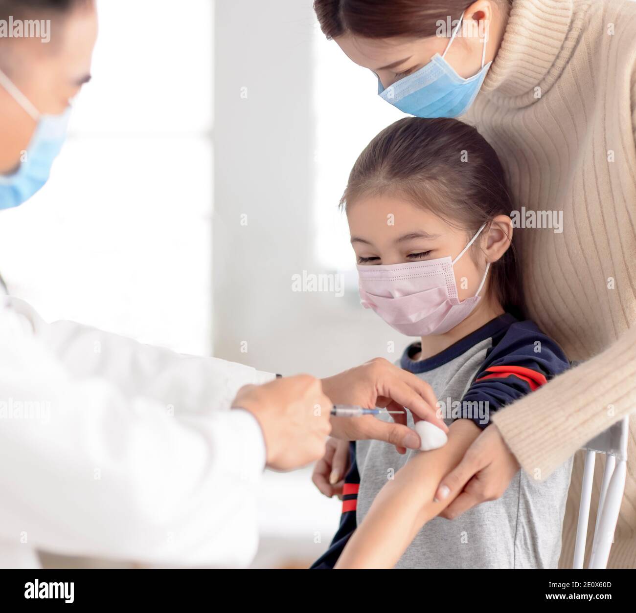 doctor examining kid and giving injection. Coronavirus vaccination and ...