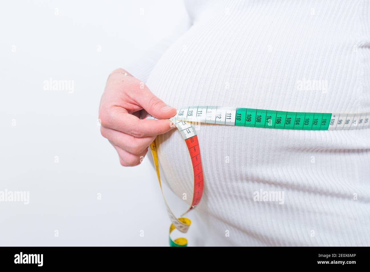 Beautiful body of pregnant woman using measuring tape to check baby ...