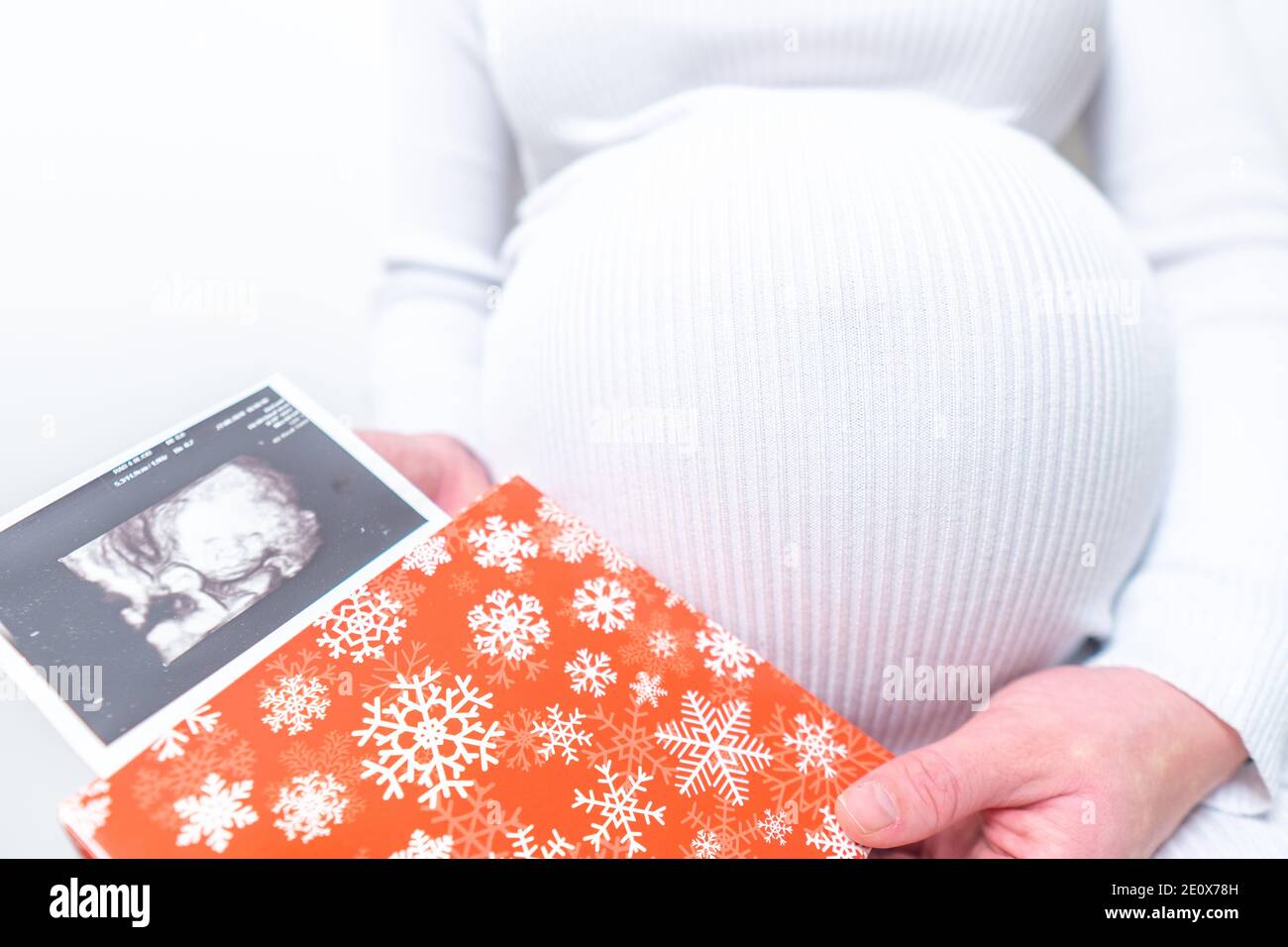 Happy pregnant woman with Christmas gift box on bed at home, closeup ...