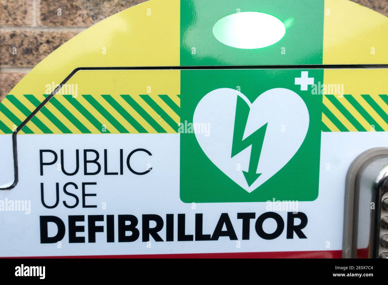 Public use emergency Defibrillator mounted on an exterior brick wall ...