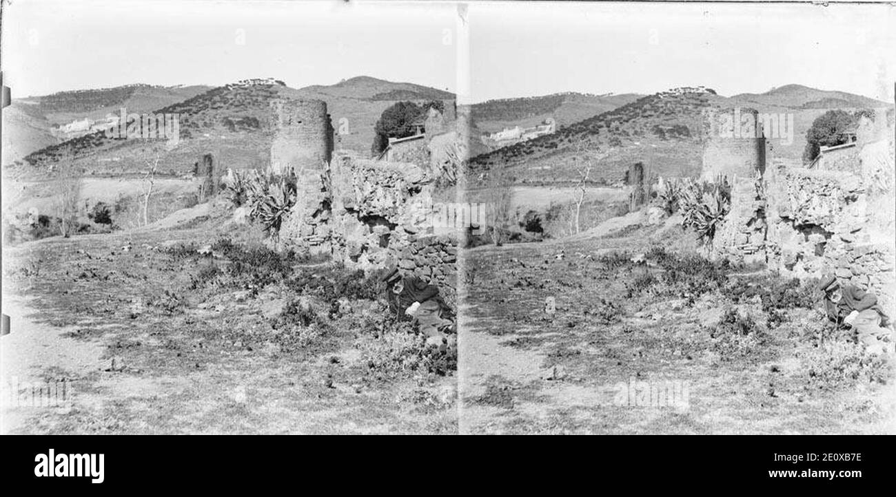 Les ruïnes del castell de Bellesguard amb una torre i un home assegut ...