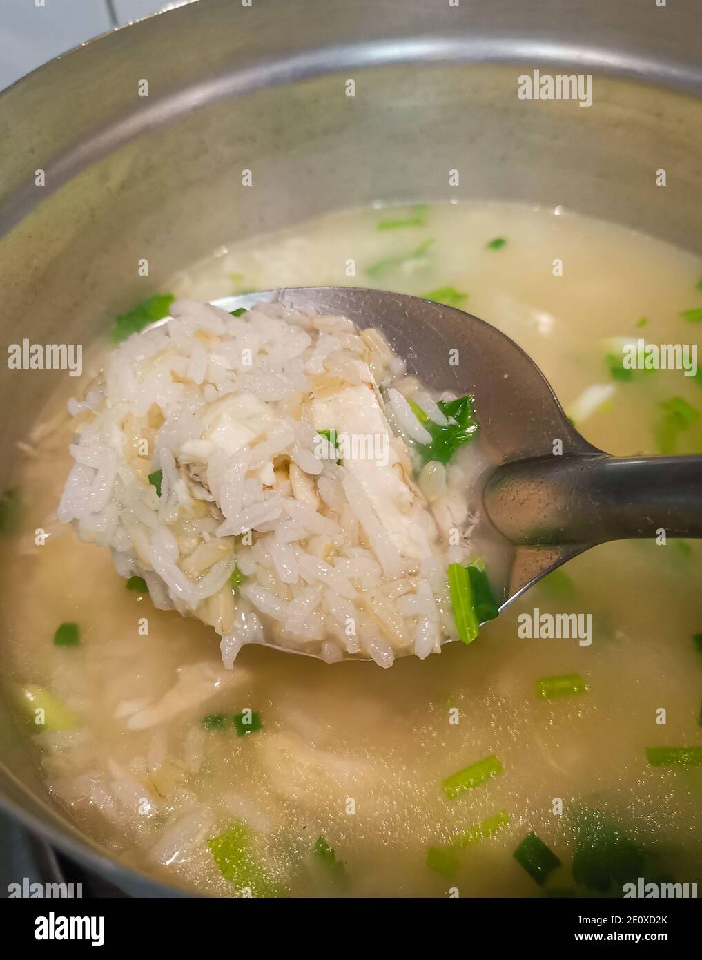 Chicken porridge with spring onion in a metal pot. The process of ...