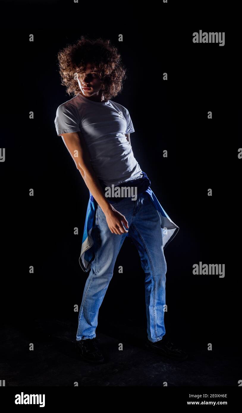 Portrait of an attractive young punk guy posing isolated on black ...
