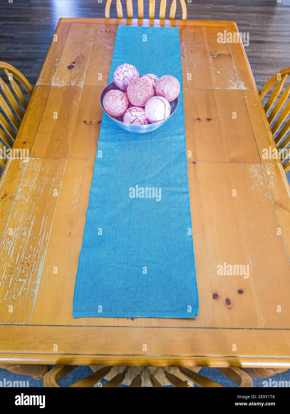 Brown rectangular dining table with blue table runner and bowl with ...