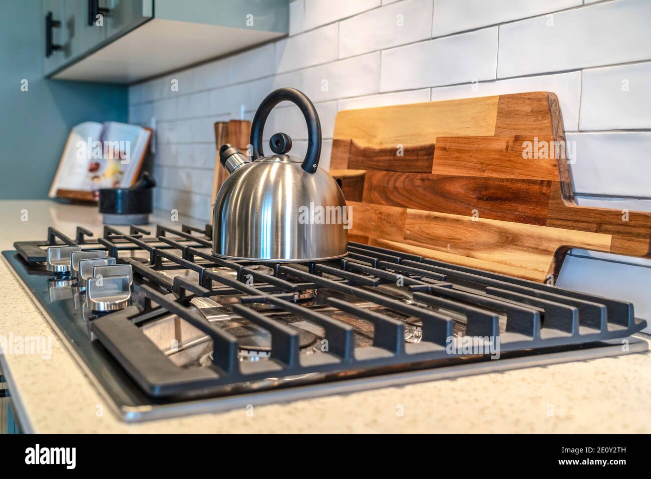 Five knobs kitchen cooktop with kettle over the burners and cast iron ...