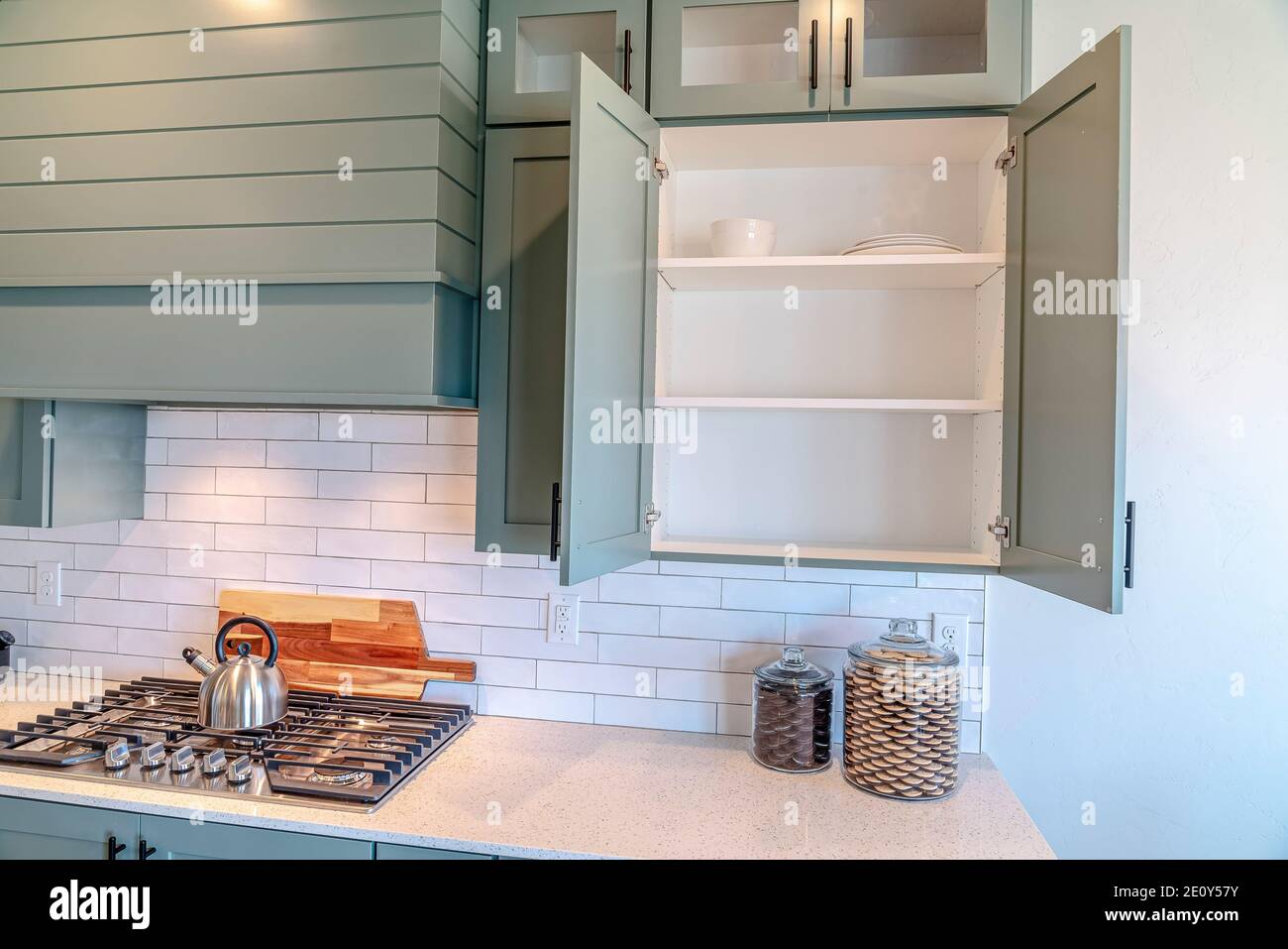 Built in cooking unit and wall cabinets inside the clean kitchen of a ...
