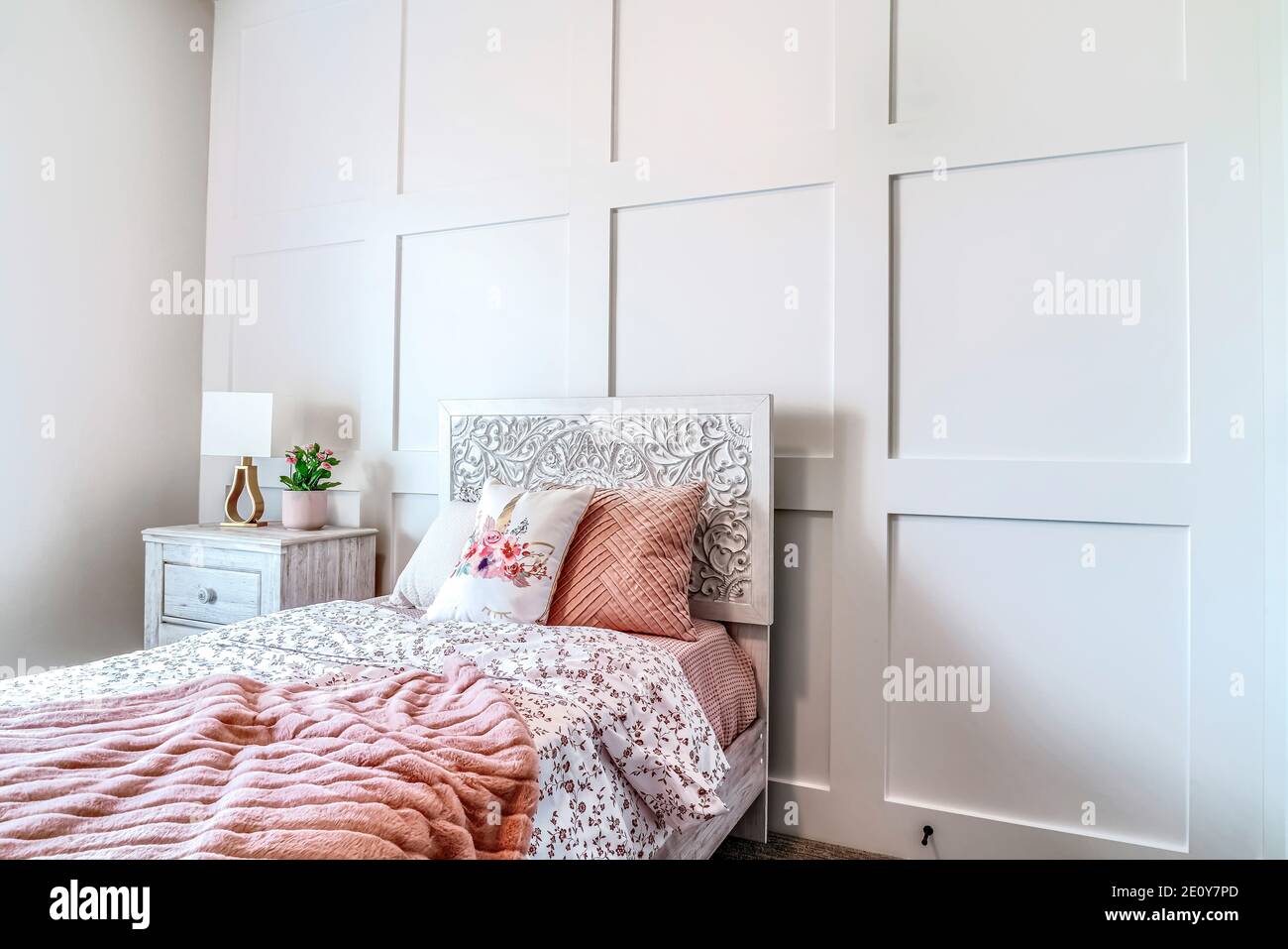 Single bed and wooden side table inside relaxing bedroom with feminine ...