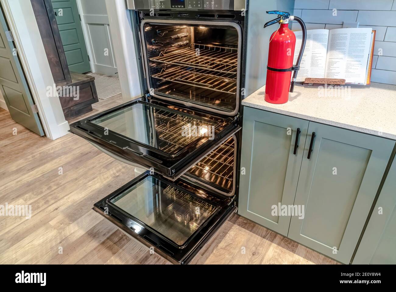 Modern electric ovens with open doors inside the clean kitchen of a ...