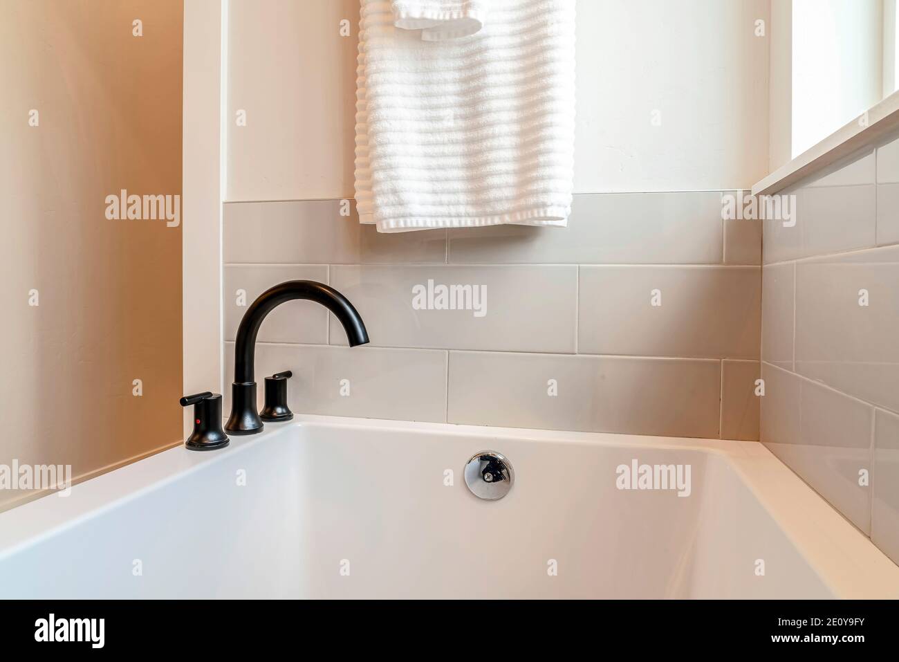 Rectangular bathtub of home bathroom with black curved faucet on the ...