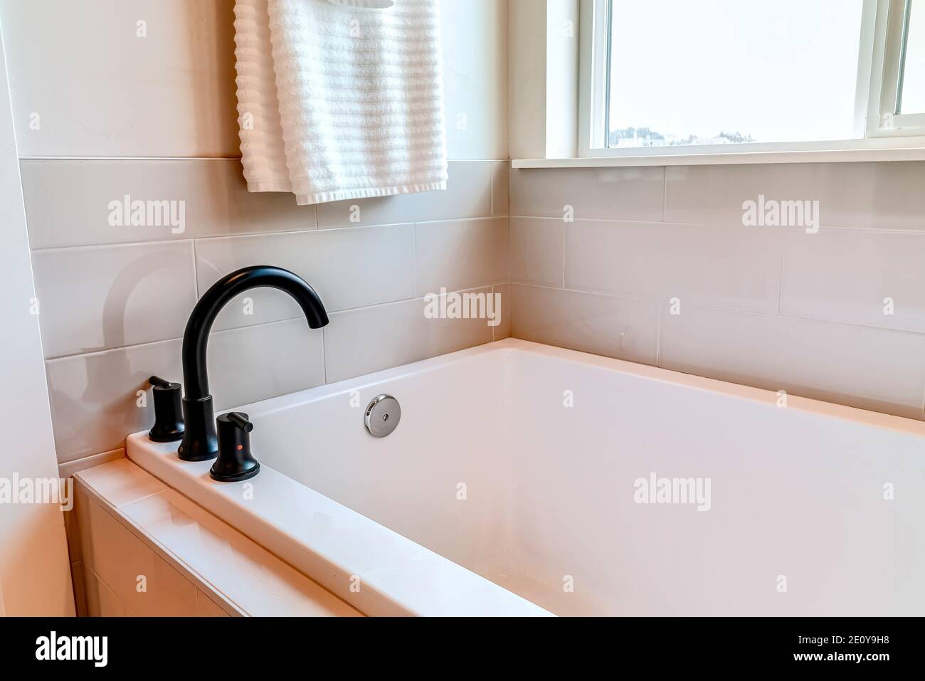 Residential bathroom interior with built in rectangular bathtub beside ...