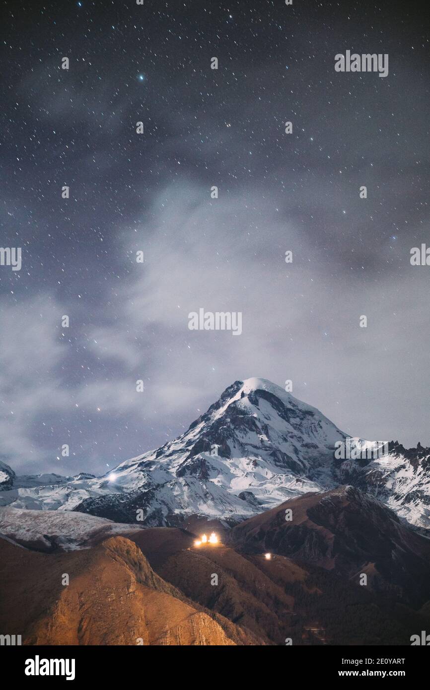 Stepantsminda, Georgia. Night Starry Sky With Glowing Stars Above Peak ...