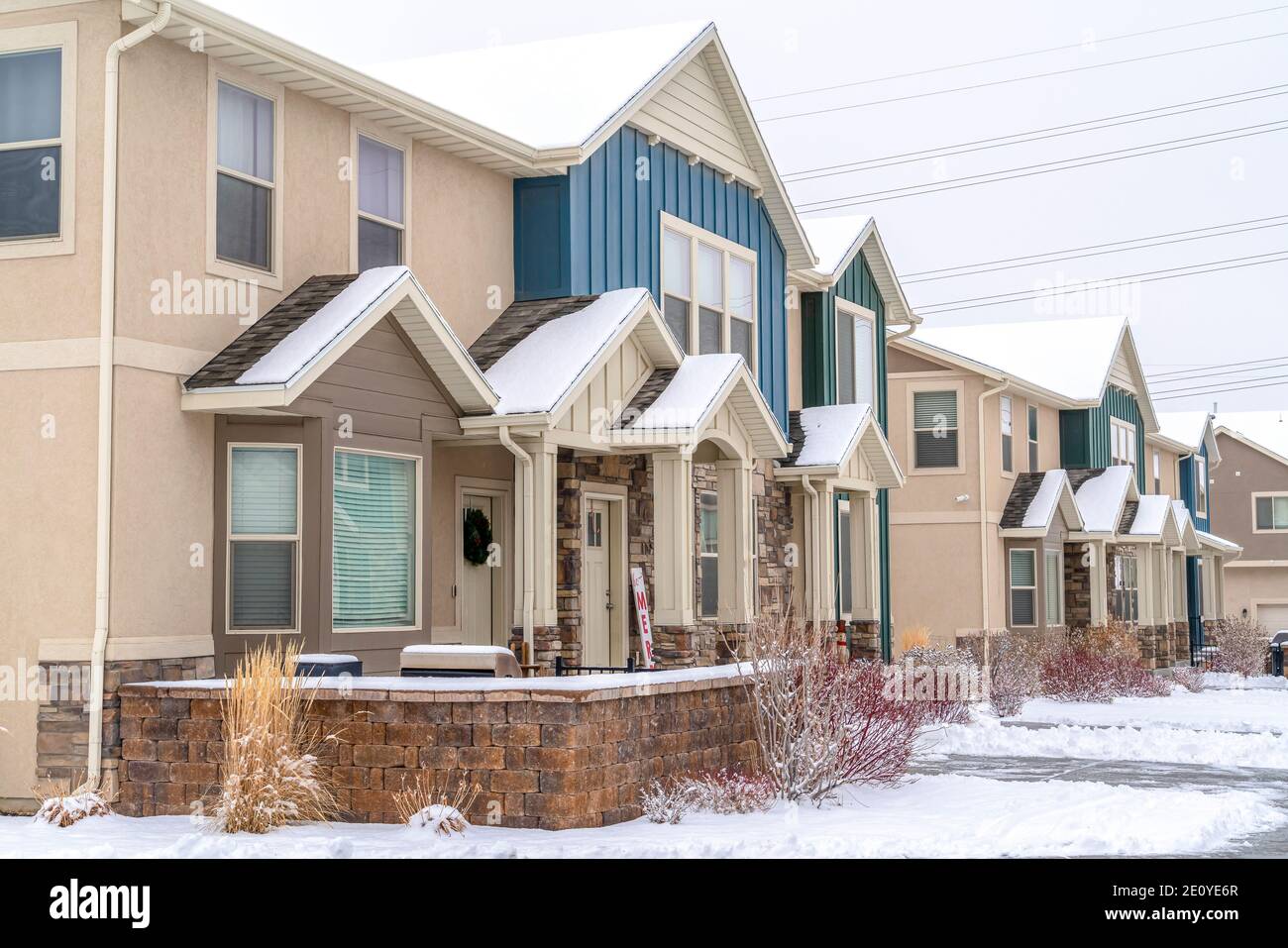 Two storey apartment homes on a snowy residential landscape during ...