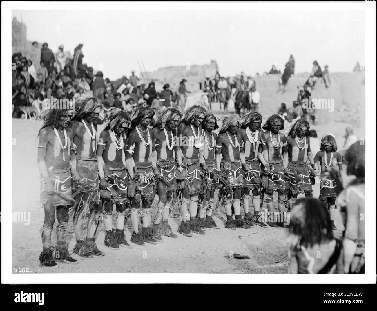 Line of a dozen Hopi snake priests singing songs and prayers before the ...