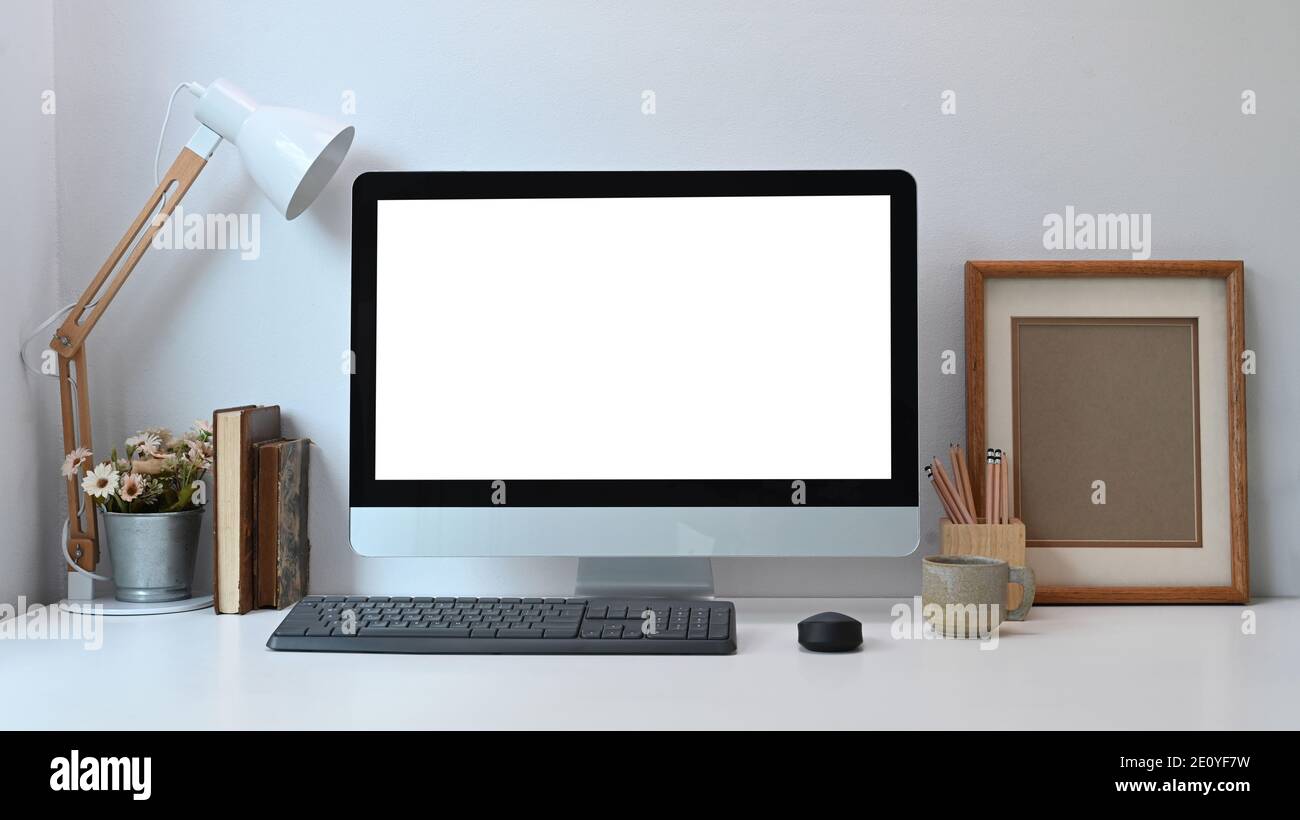 Front view of contemporary workspace with white blank screen monitor ...