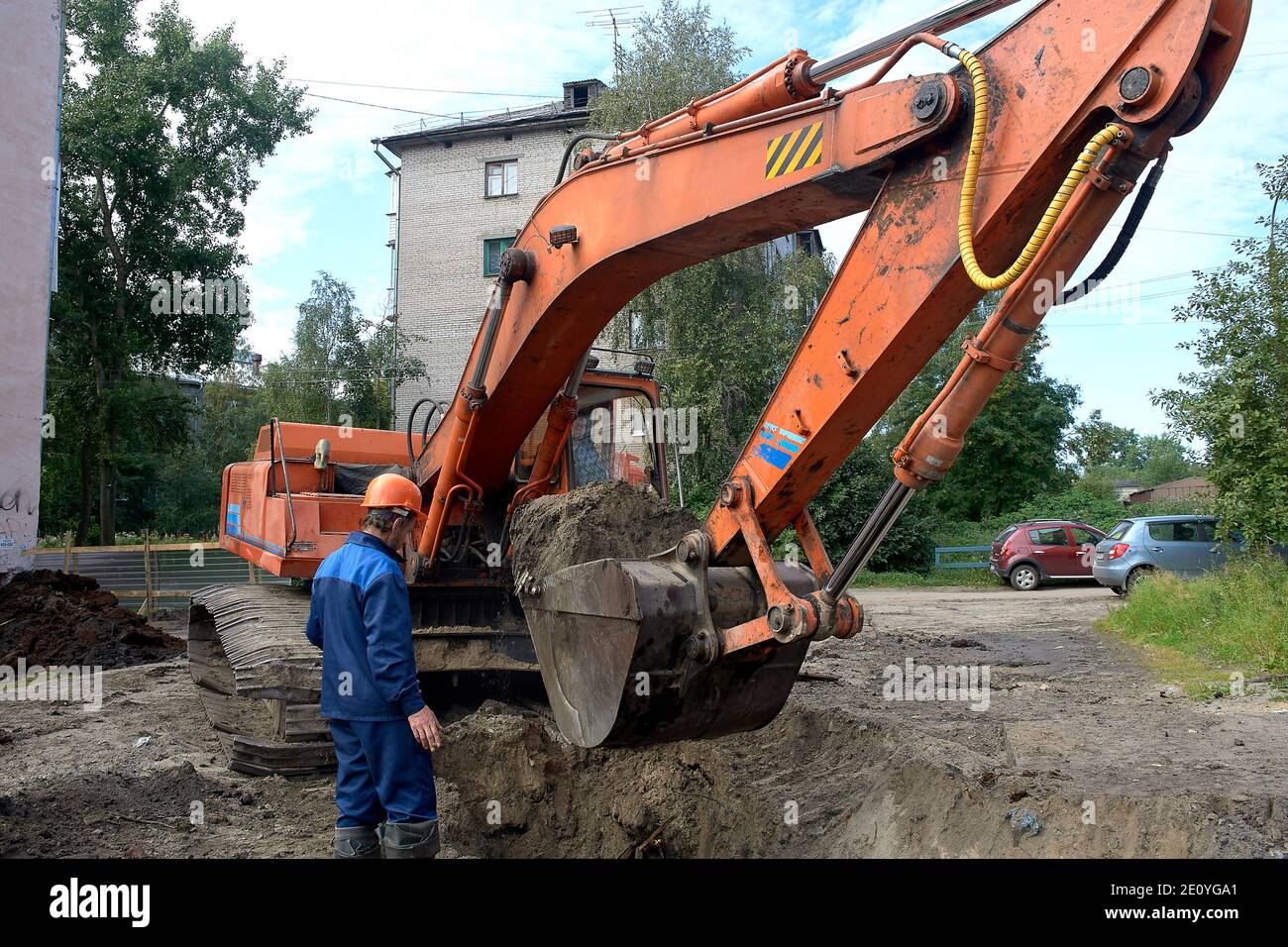 Excavator performs earthworks in the city Stock Photo - Alamy