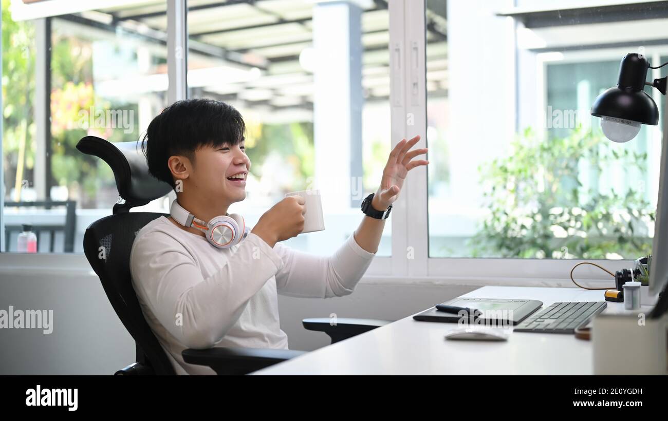 Shot of a cheerful man having video call on computer with colleagues ...