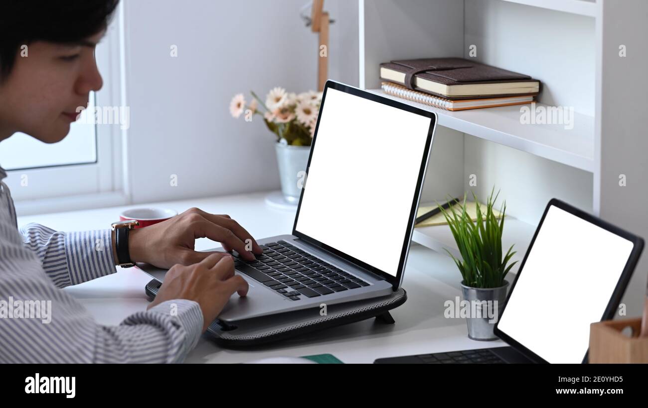 Cropped shot of male freelance working with multiple device at his ...