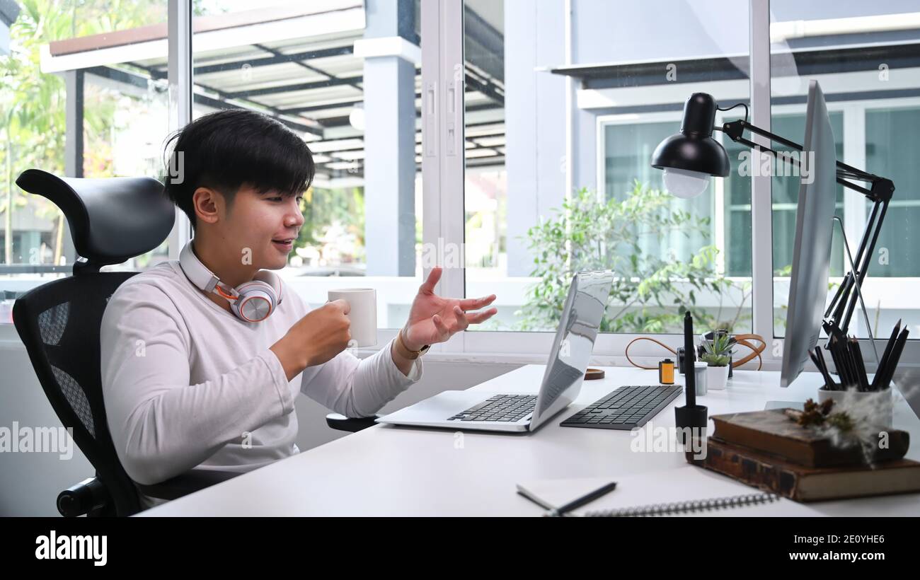 A cheerful man with headphone having video conference meeting with ...