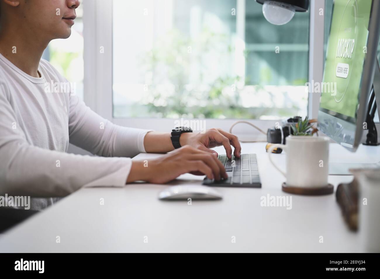Side view of young man hand working on computer at his comfortable ...