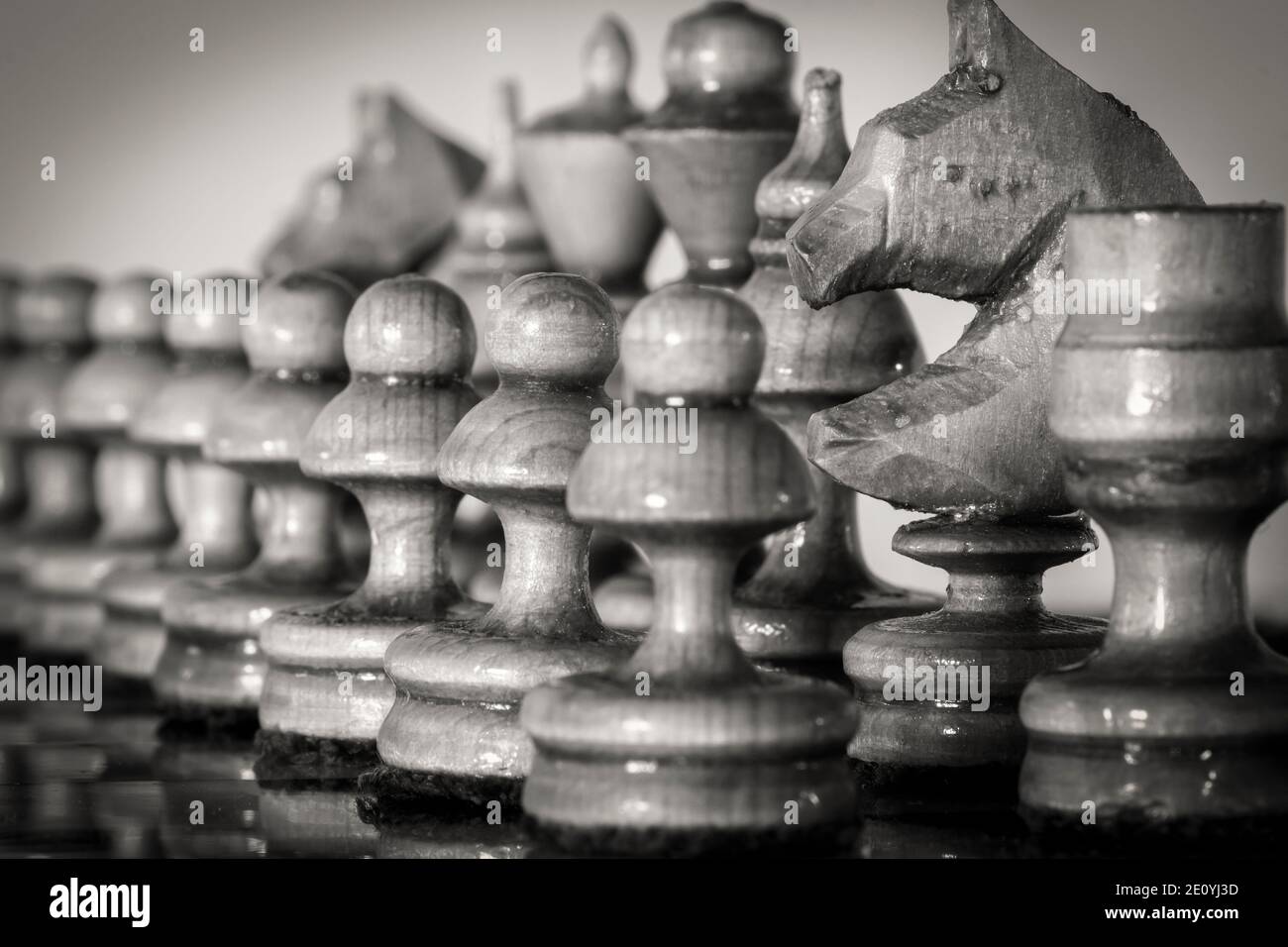 Wooden chess pieces stand on the board in the starting position before ...