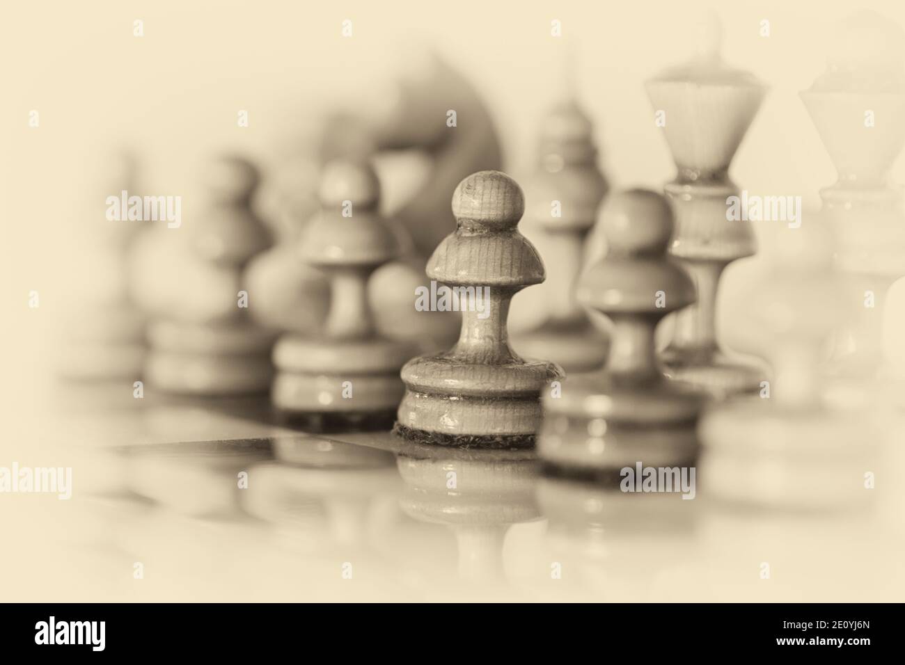 Wooden chess pieces stand on the board in the starting position before ...