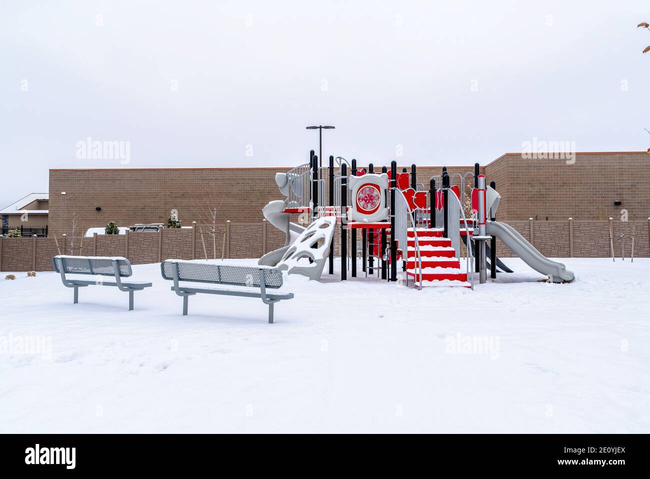 Park with playground and benches in a frosted neighborhood on a snowy ...