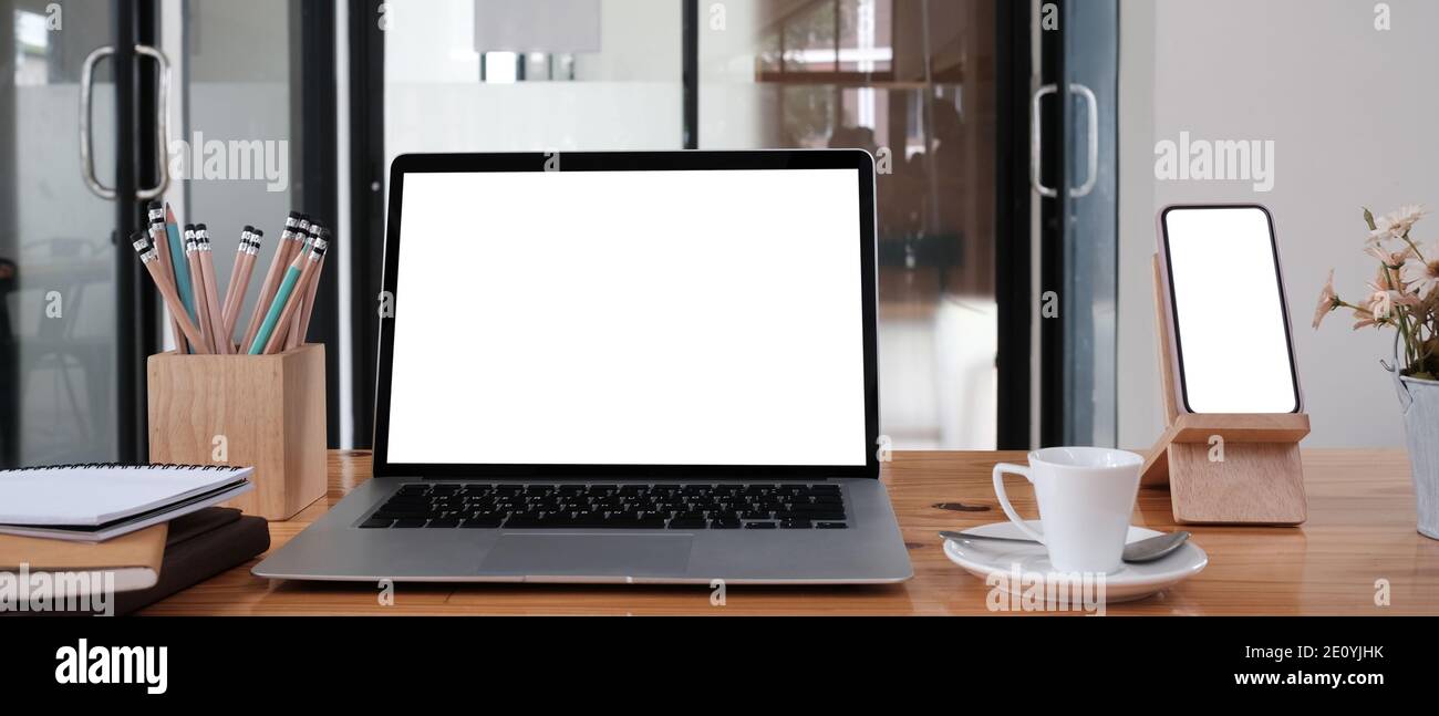 Front view computer laptop and mobile phone on white office desk. Blank ...