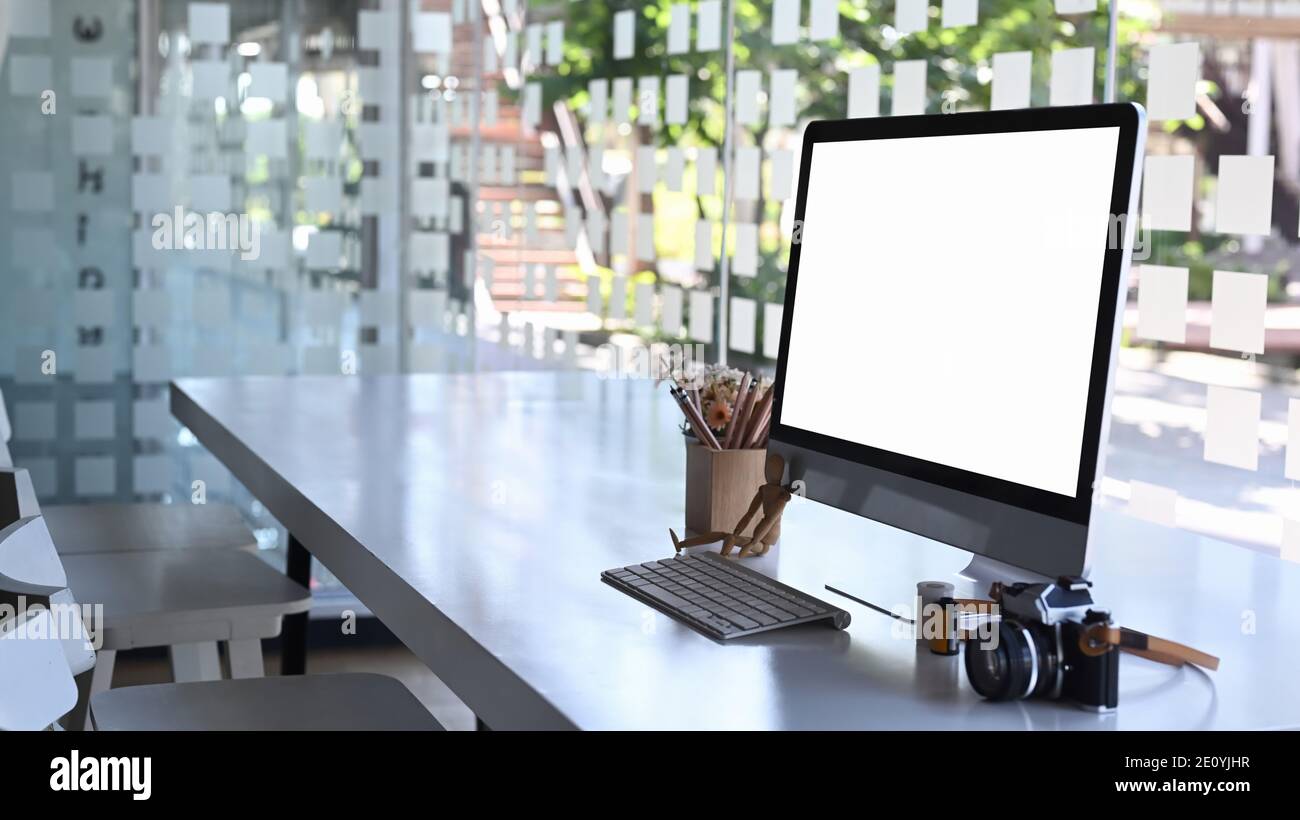 Side view of computer with white screen at photographer workspace Stock ...
