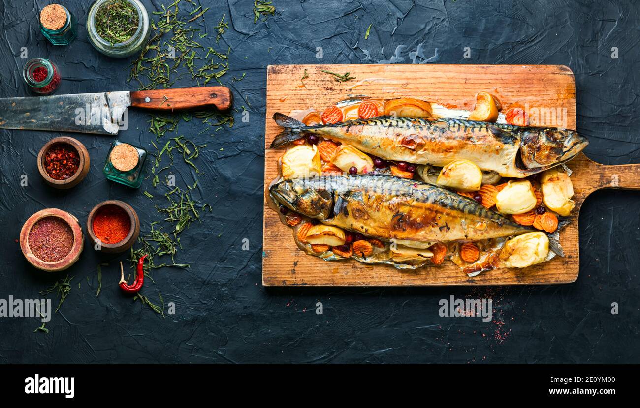 Delicious mackerel fish roasted with apples,served on kitchen board ...