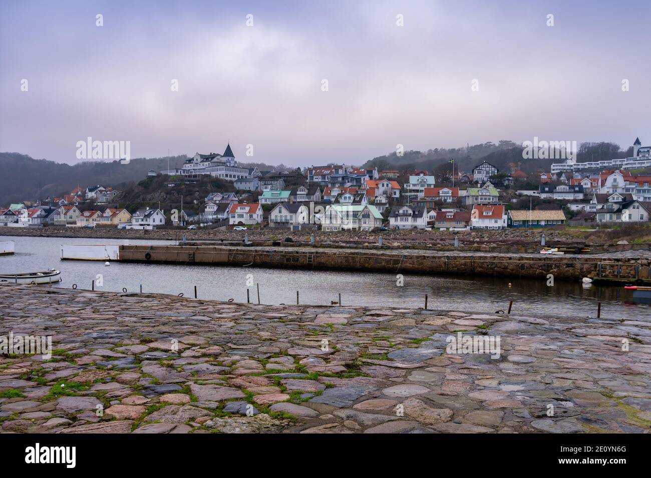An empty marina in the winter. Mountains in fog in the background ...