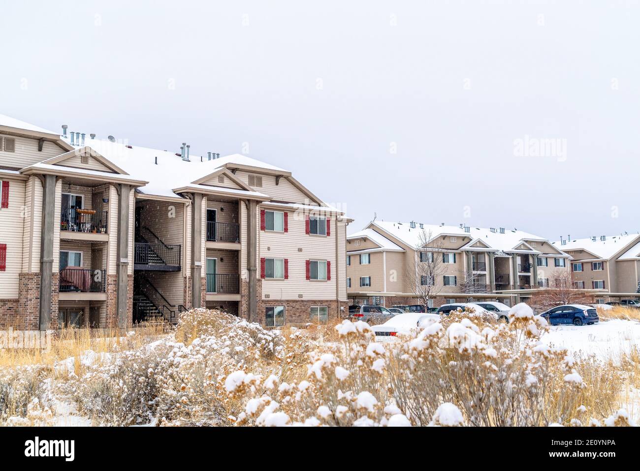 Apartment buildings and townhouses at a snowy neighborhood in winter ...
