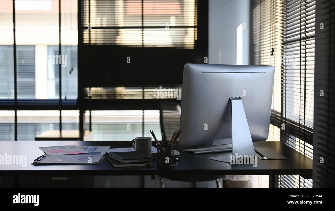 Rear view of office desk with computer, business documents and ...