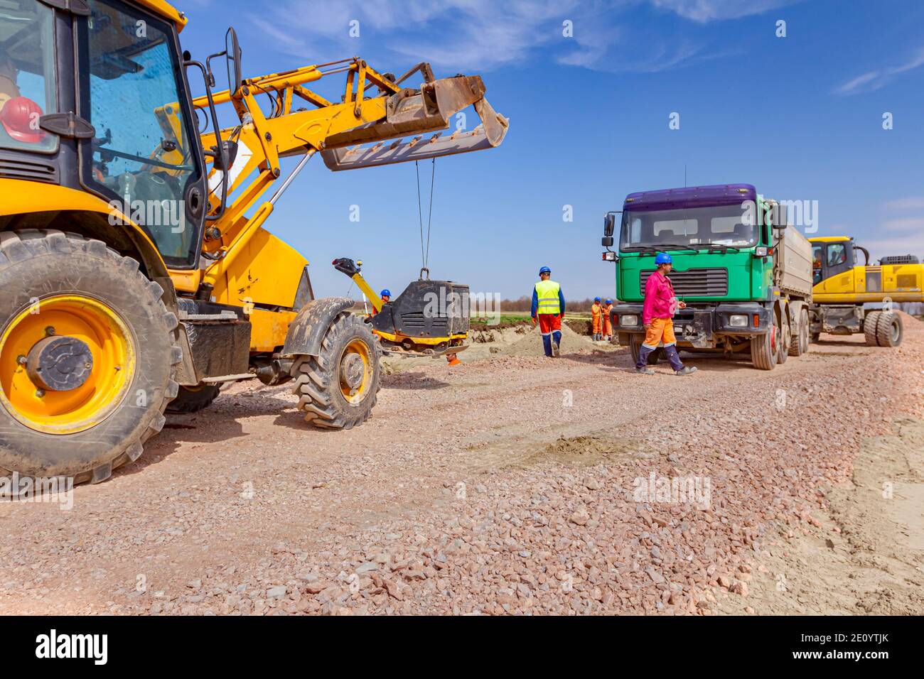 Excavator is carry, over building site with raised up front bucket ...