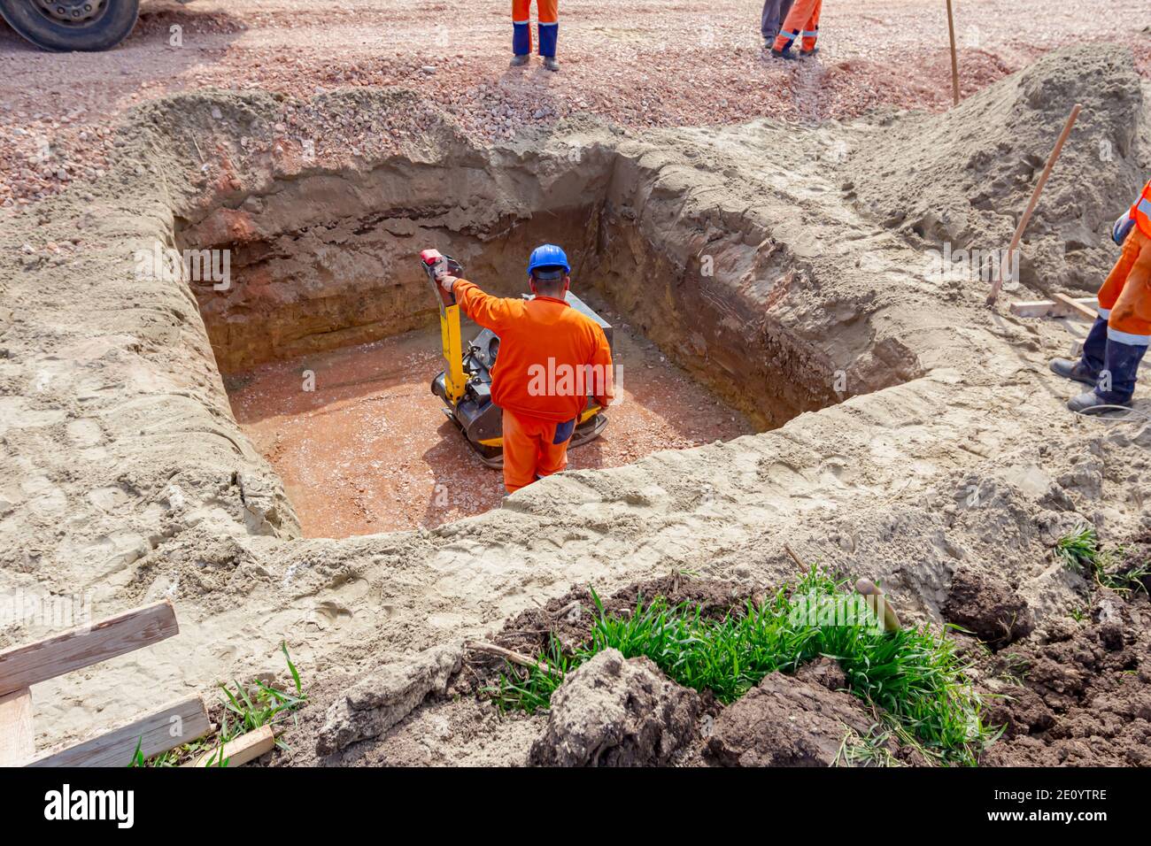 Worker is compacting gravel with vibration plate compactor machine in ...