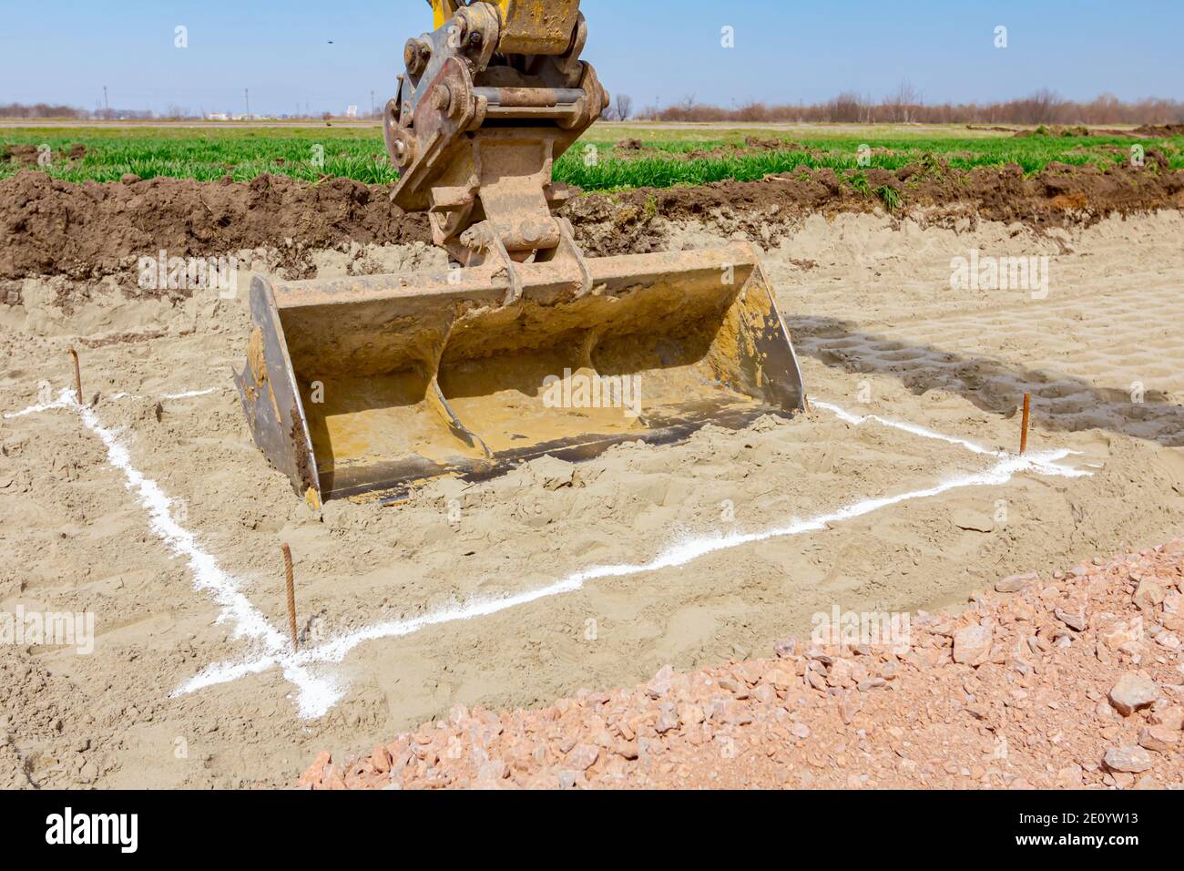 Excavator will excavate square trench that is marked with white powder ...