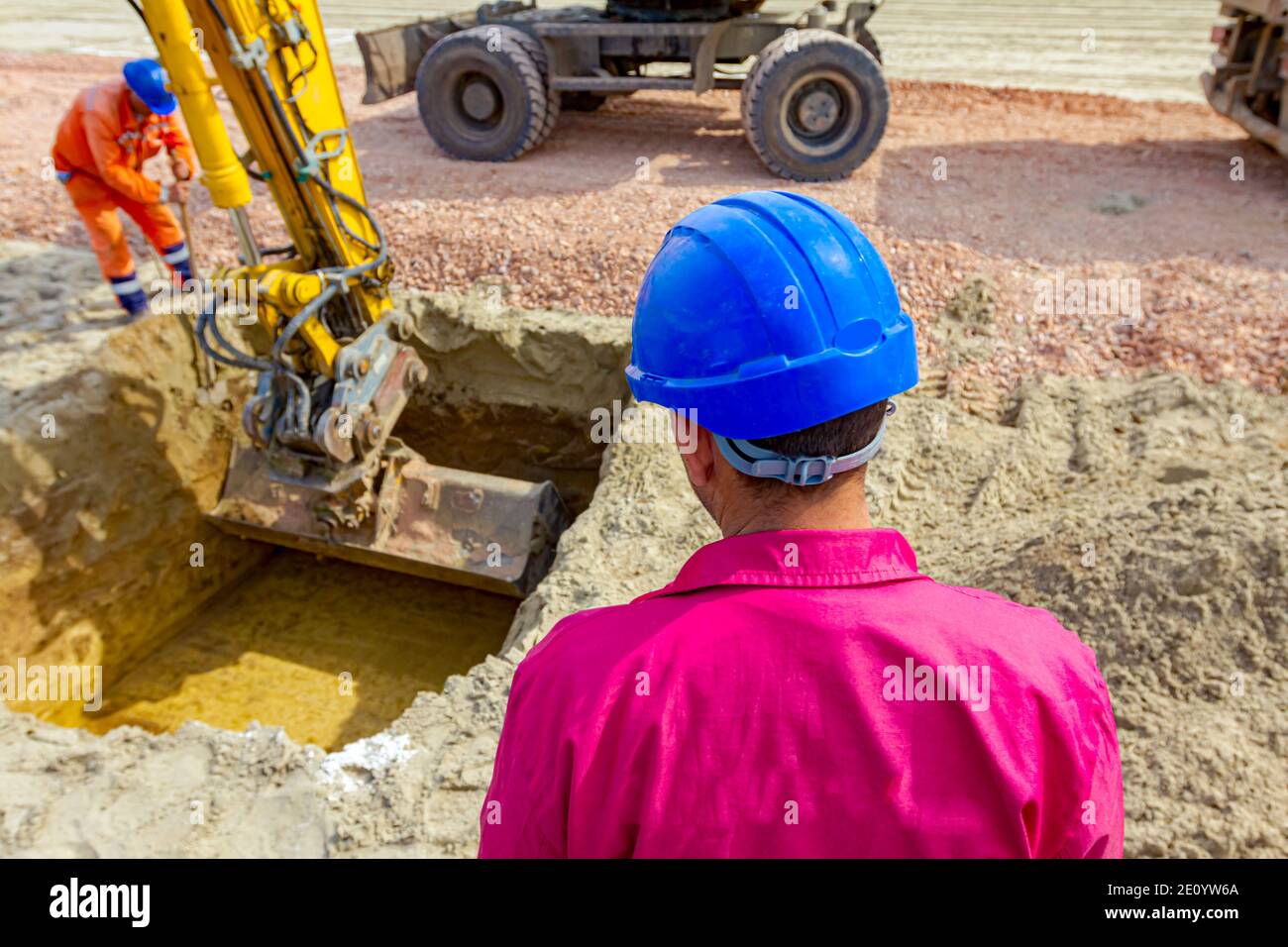 View from behind on construction worker, foreman, with safety blue ...