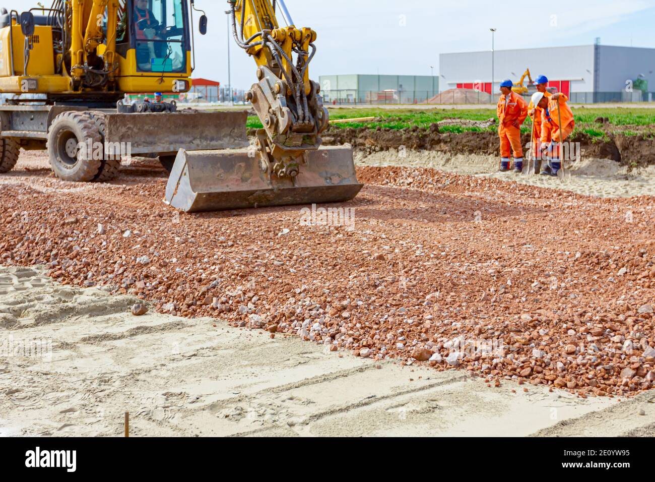 Excavator is level fraction, small crushed stone, with his front bucket ...