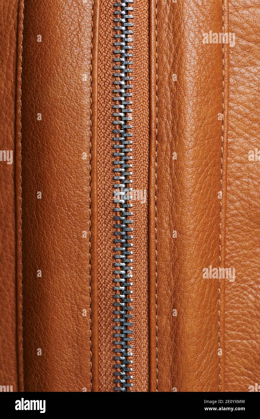 Unzipped line on brown leather macro close up view Stock Photo - Alamy