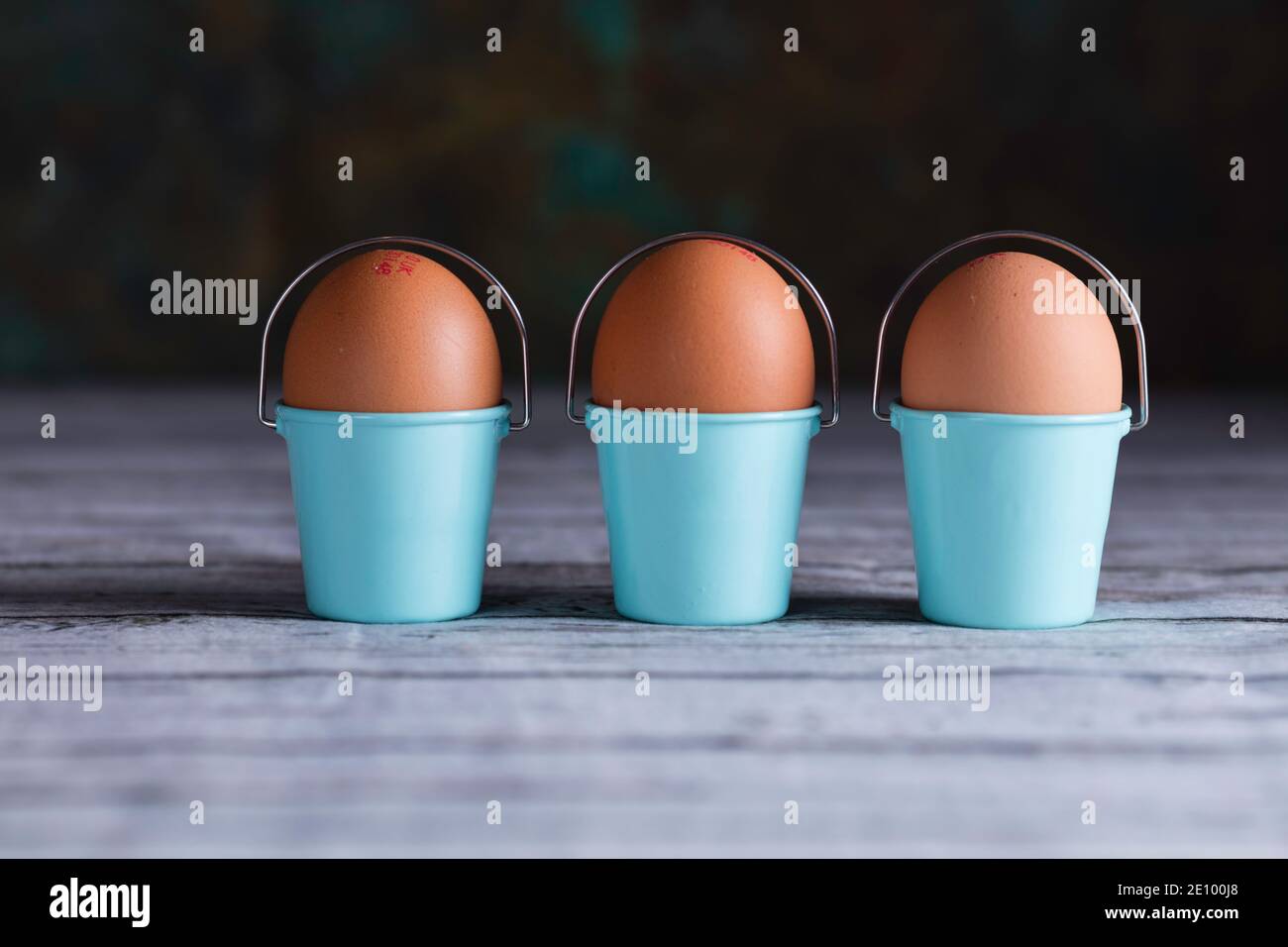 Three eggs in bucket-shaped egg cups Stock Photo - Alamy