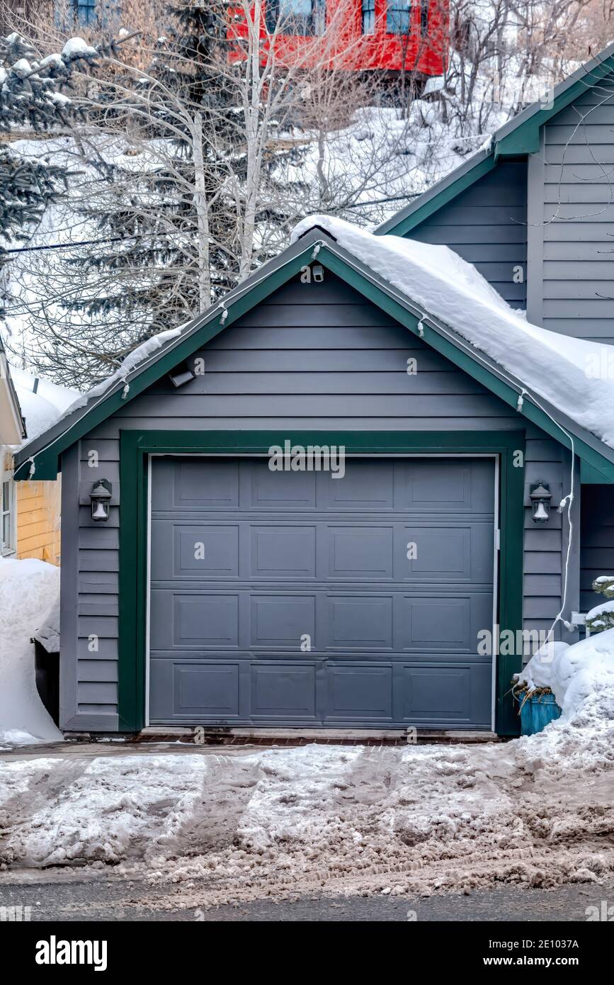 Front view of garage against a snow covered neighborhood landscape in ...