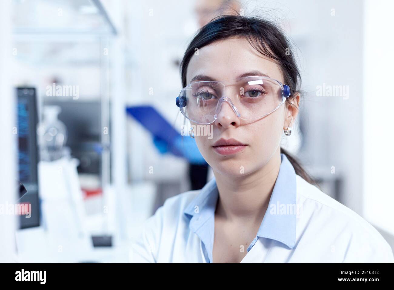 Close up portrait of virus researcher in scientific laboratory looking ...