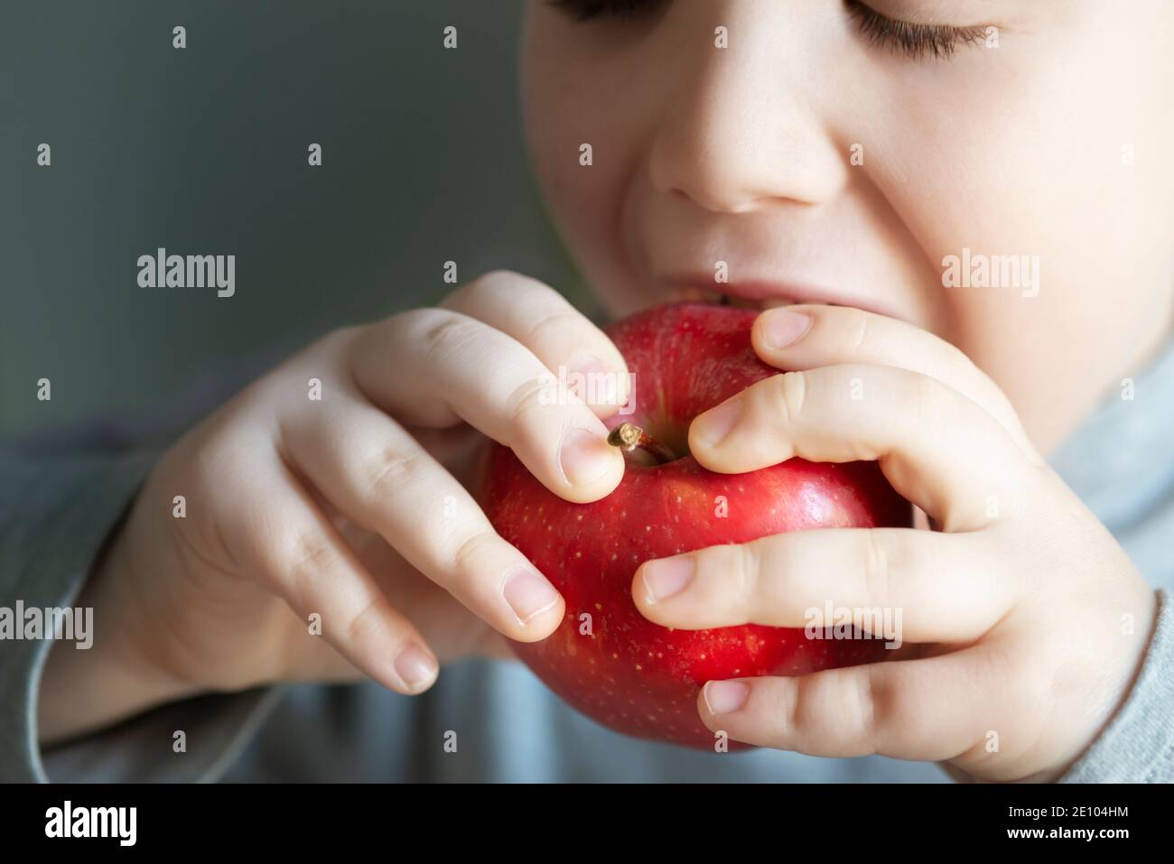 Boy Biting a Red Apple Stock Photo - Alamy