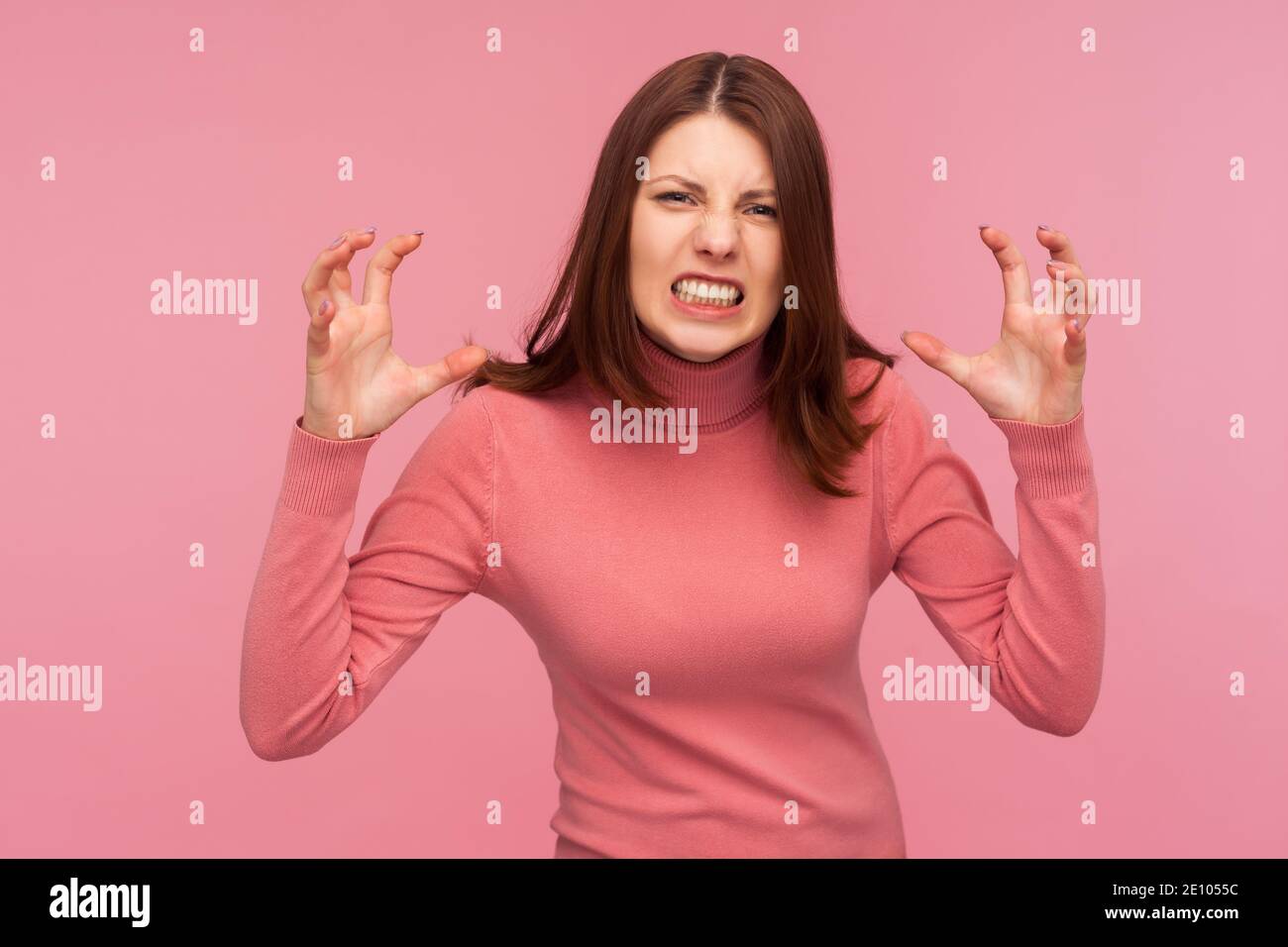 Extremely angry furious woman with brown hair grimacing and clenching ...
