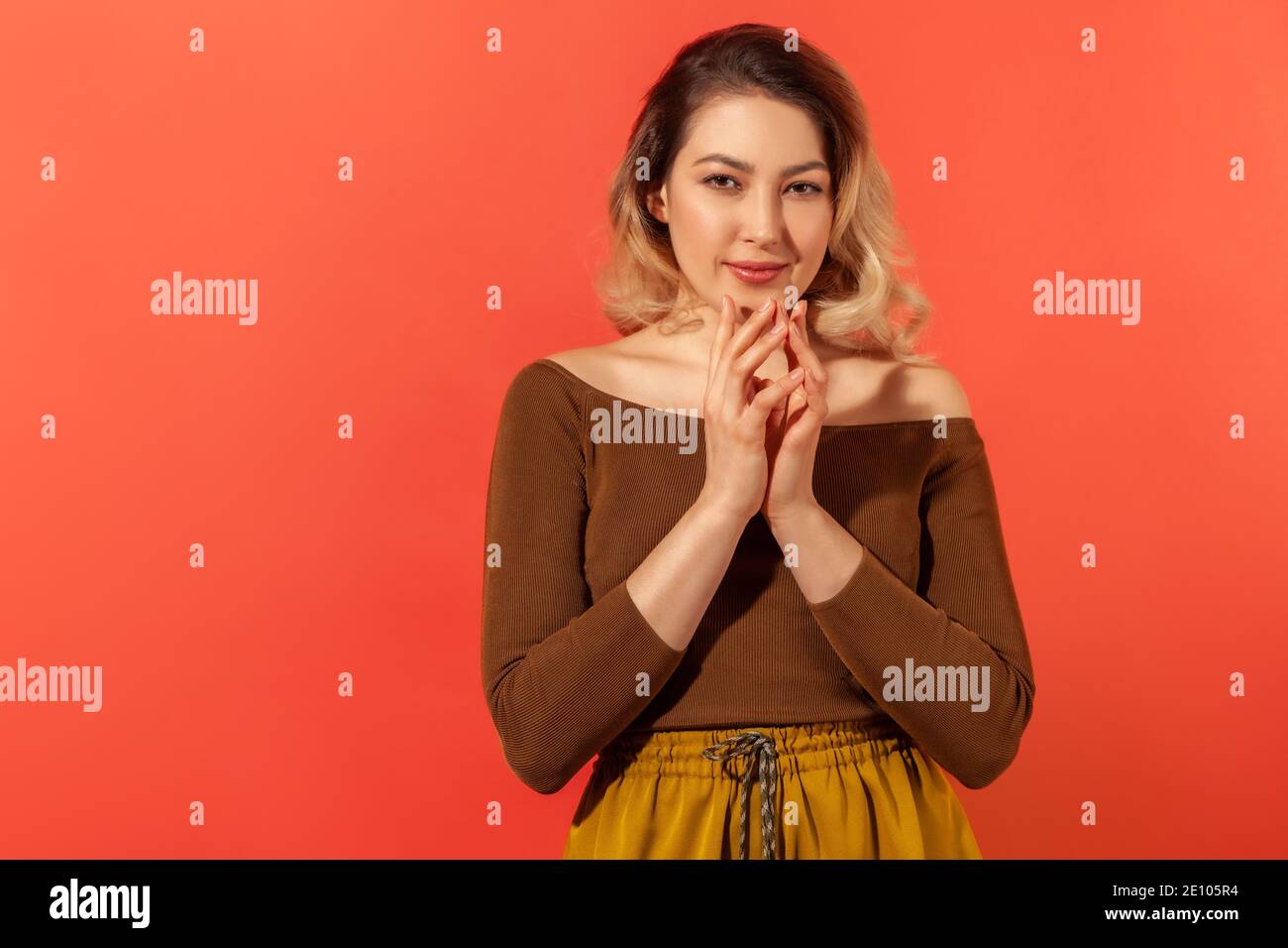 Portrait of sneaky scheming young woman in brown blouse thinking ...