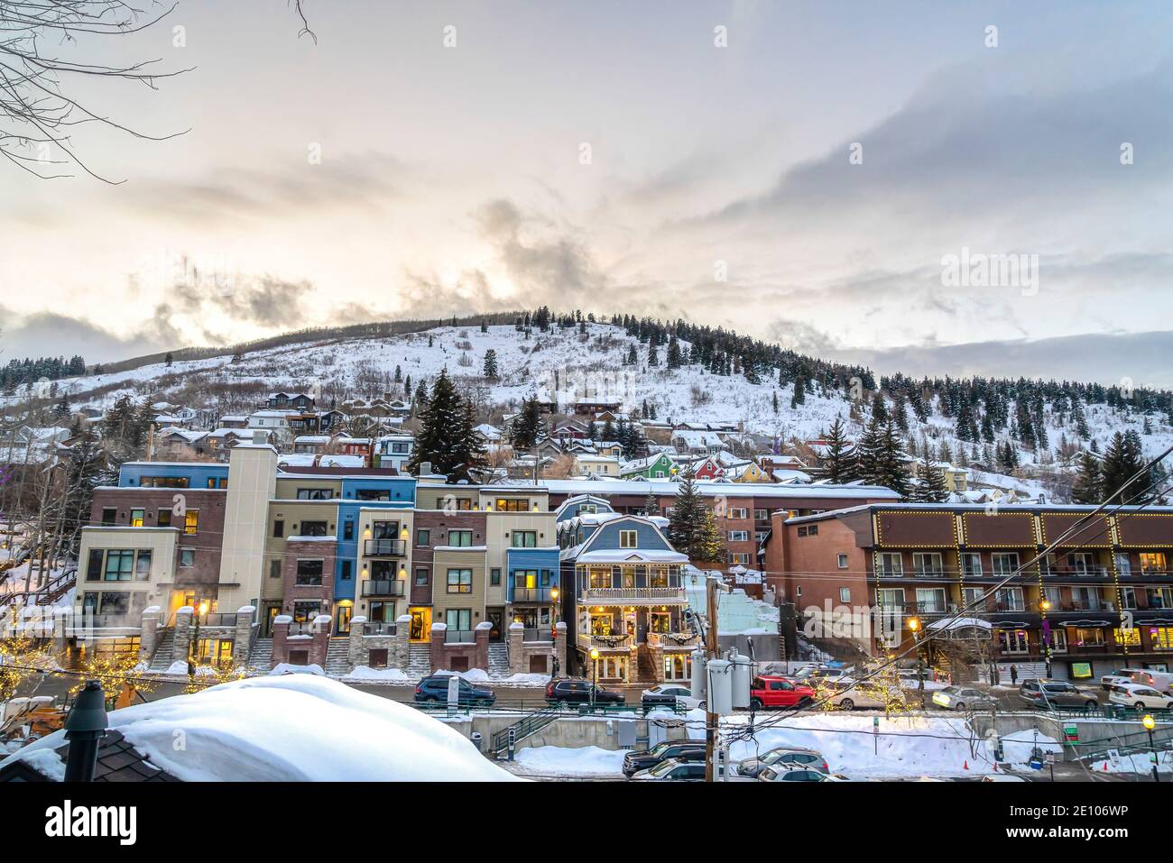 Scenic town with buildings and houses on snowy mountain against cloudy ...